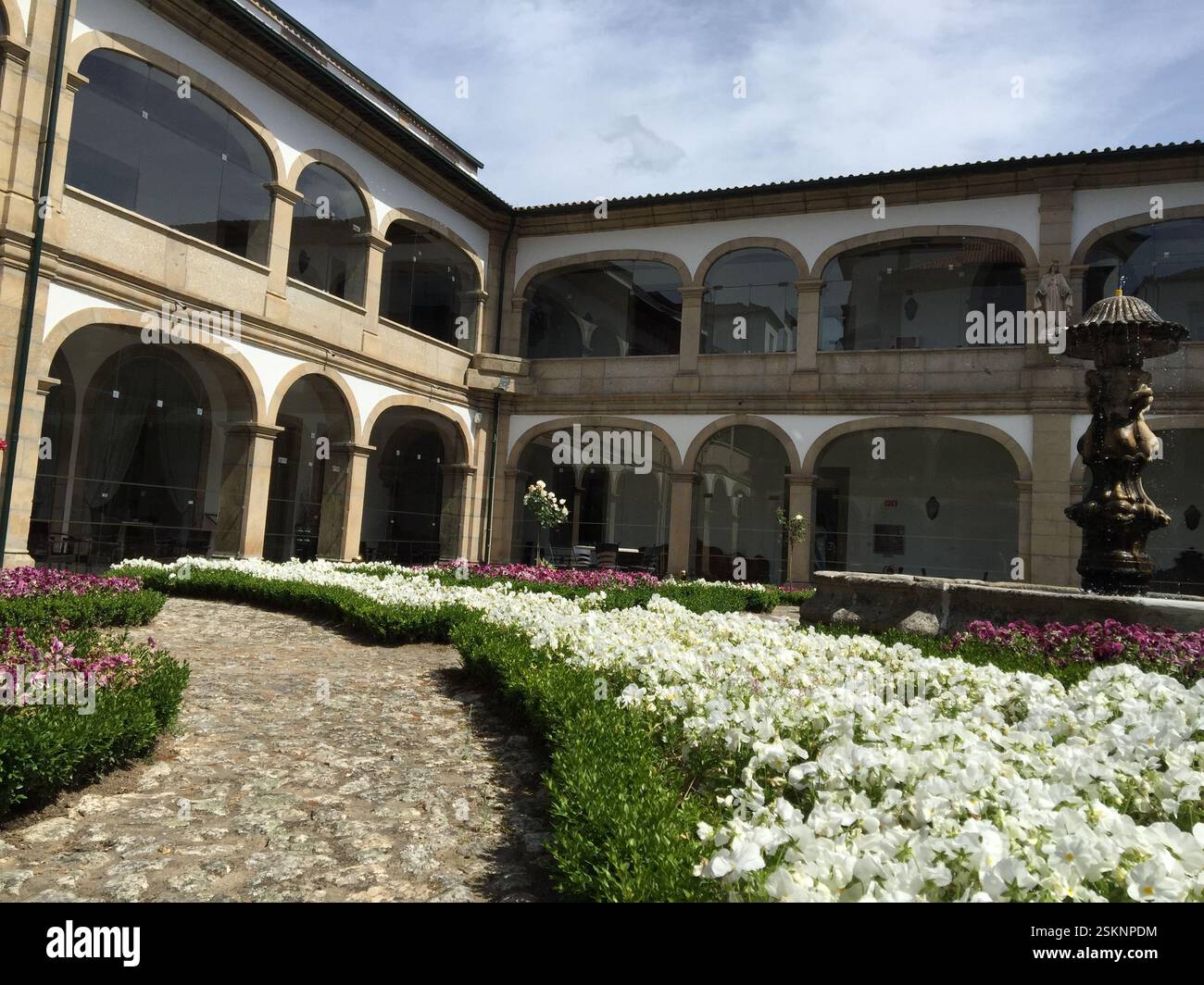 Stone courtyard, Braga, Portugal, arched walkways, lush greenery ...