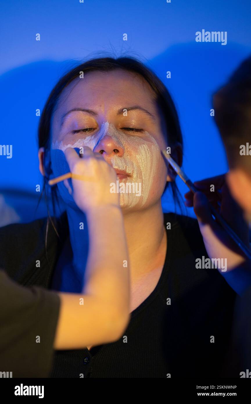 Close-up view of a person having a white facial mask applied with ...