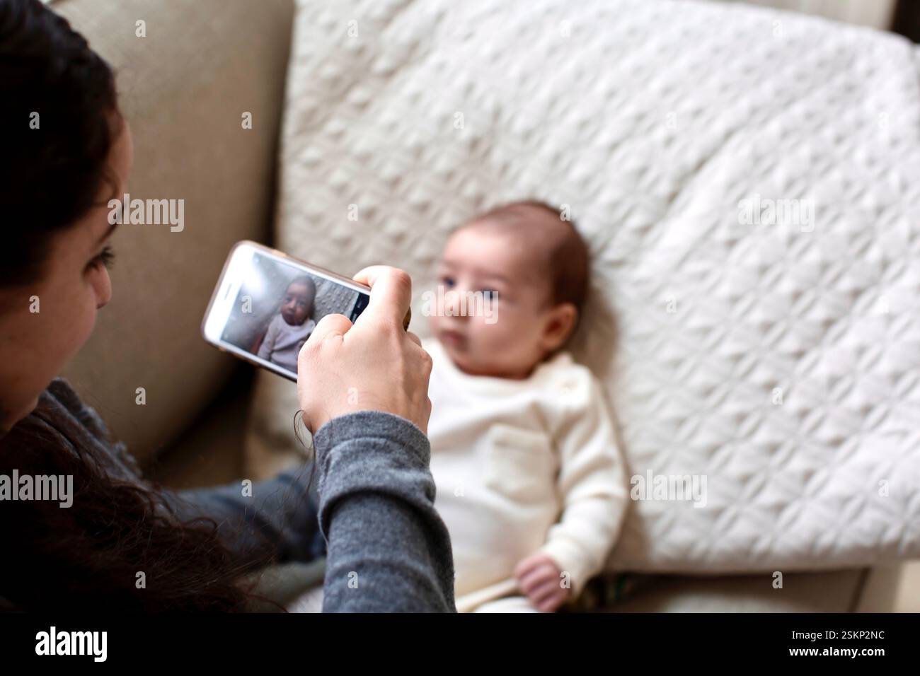 Woman on a mobile holding baby hi-res stock photography and images - Alamy