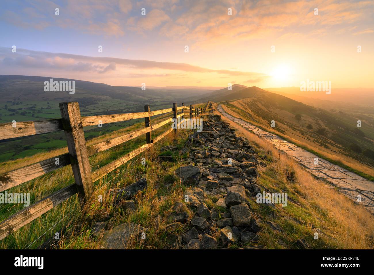 Golden sunrise at Mam Tor with footpath leading along ridge in The Peak ...