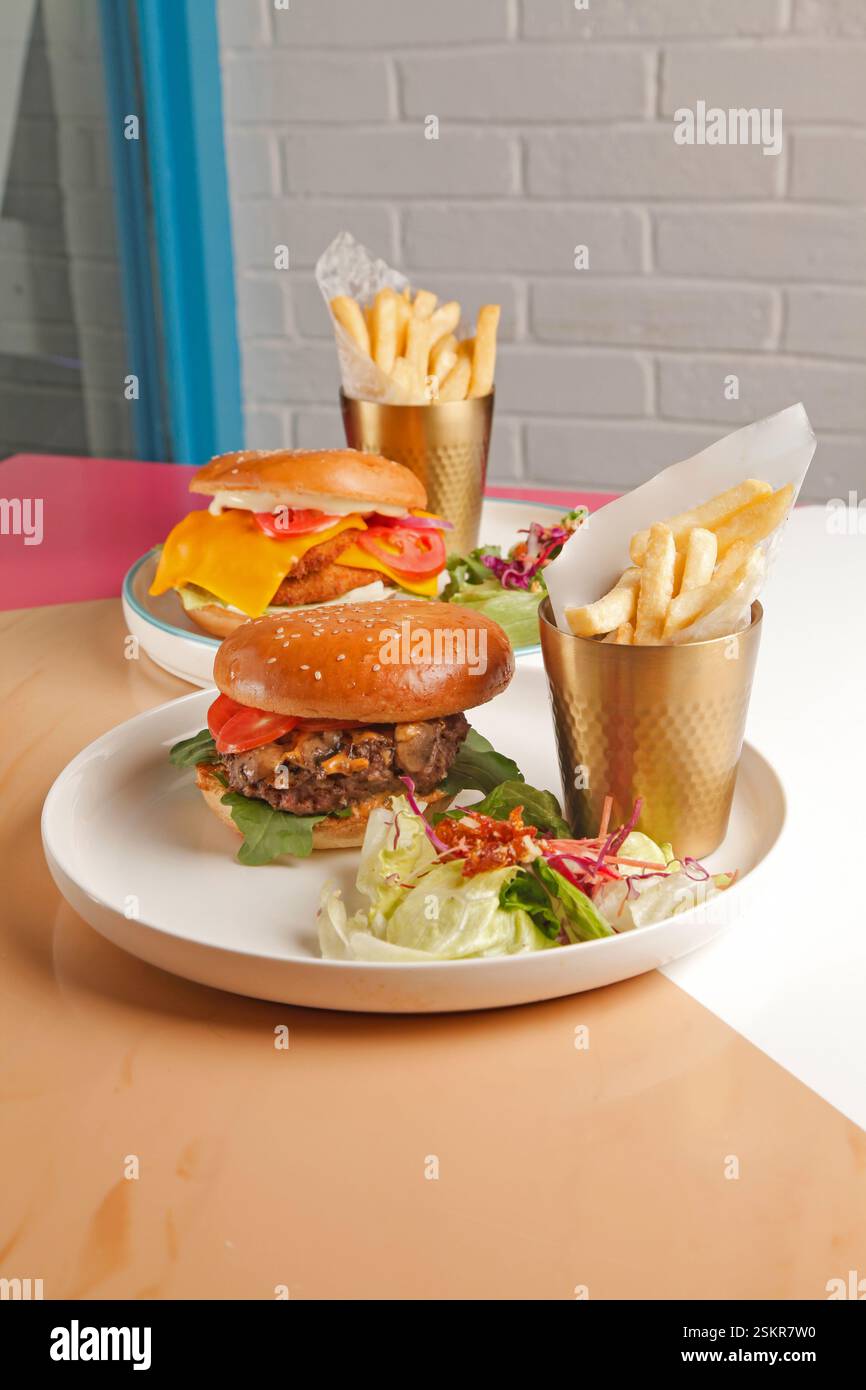 Gourmet beef and fried chicken burgers served with hand cut fries on a ...
