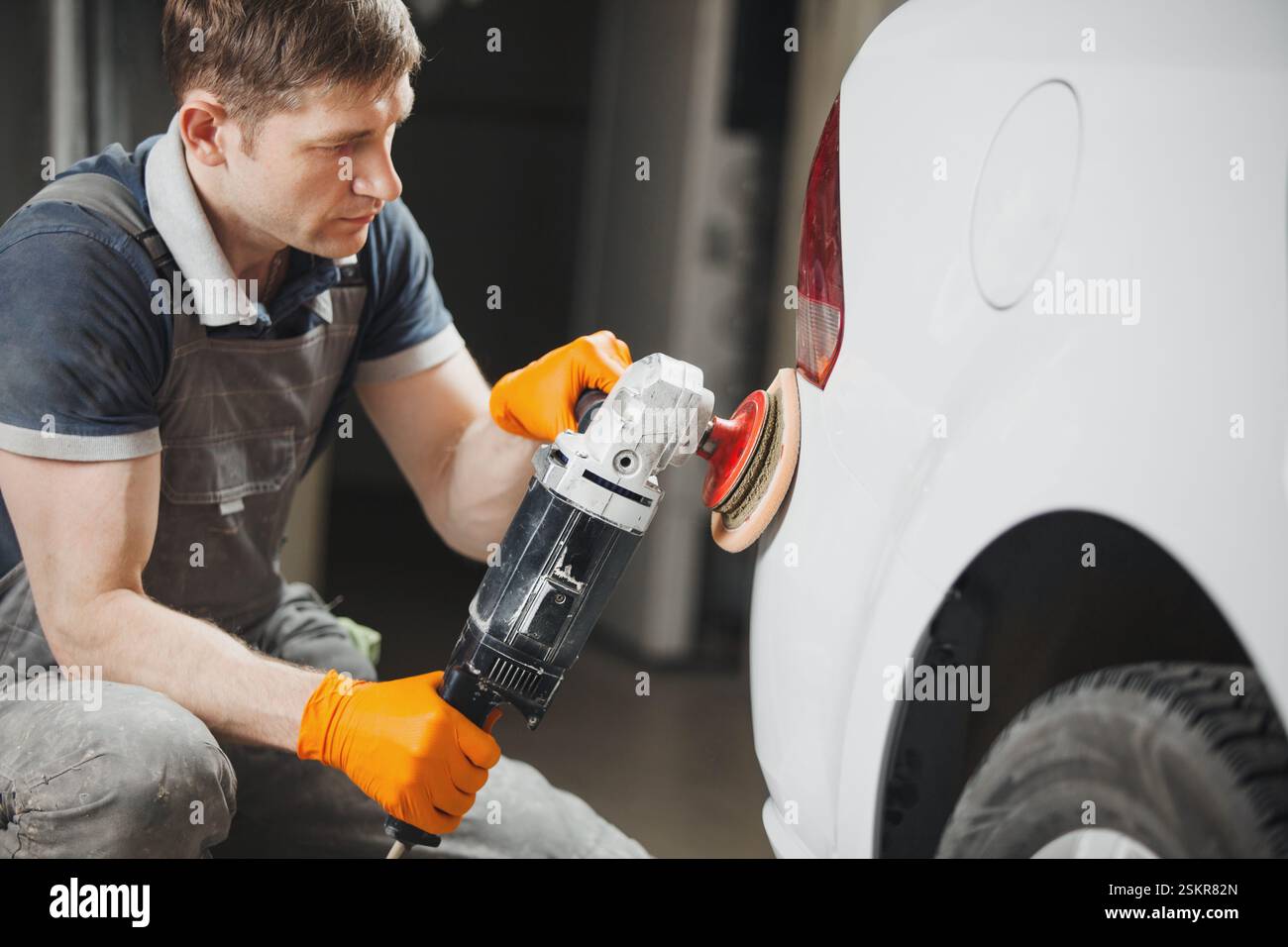 Car detailing. Man works with orbital polisher and polishing white ...