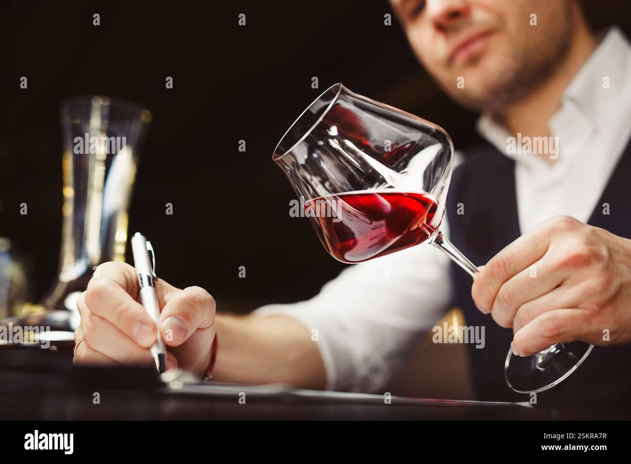 Sommelier of fine restaurant tastes red drink, fills form Stock Photo ...