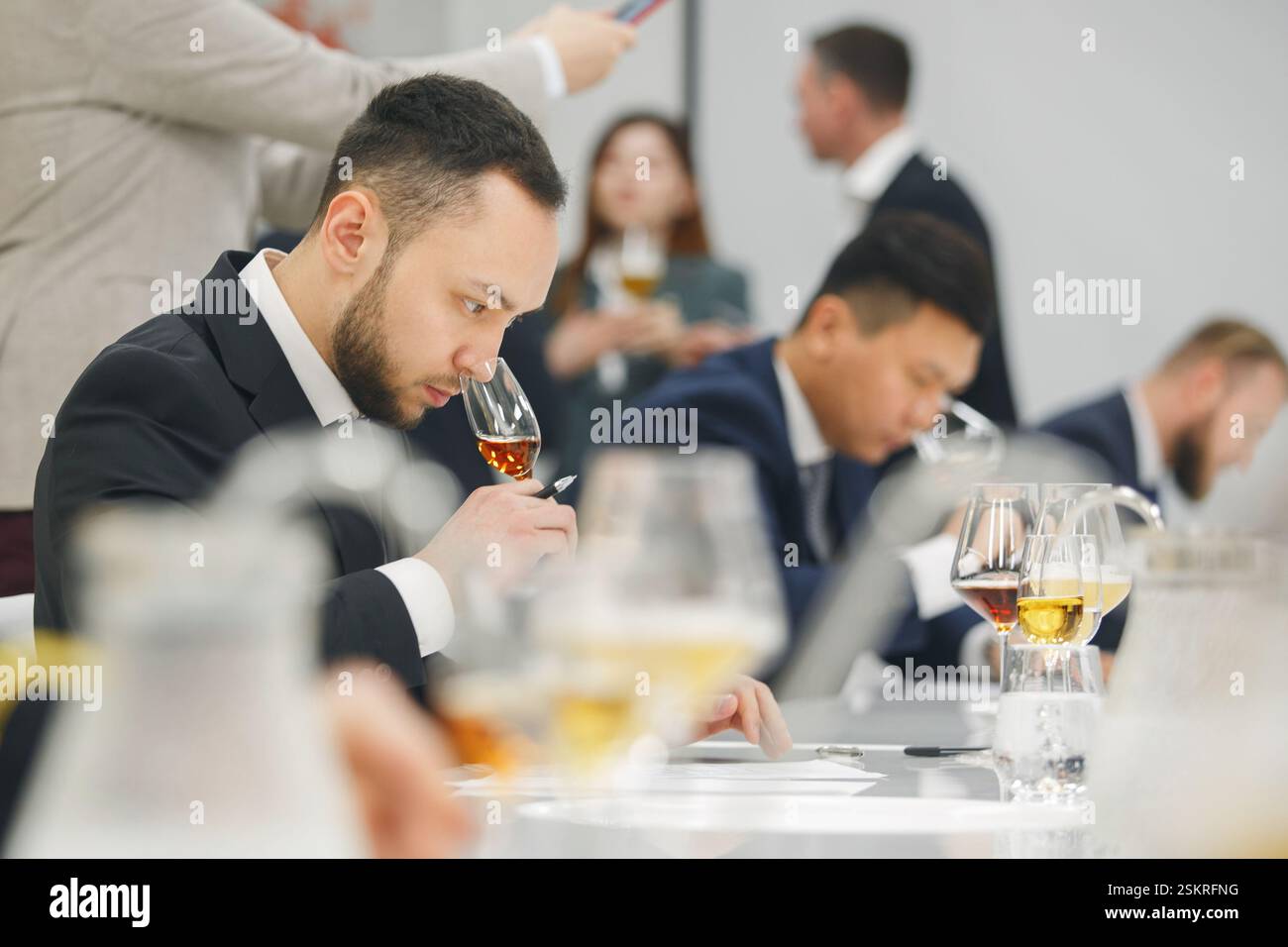 Beginner wine waiter sniffs alcoholic drink during blind tasting ...