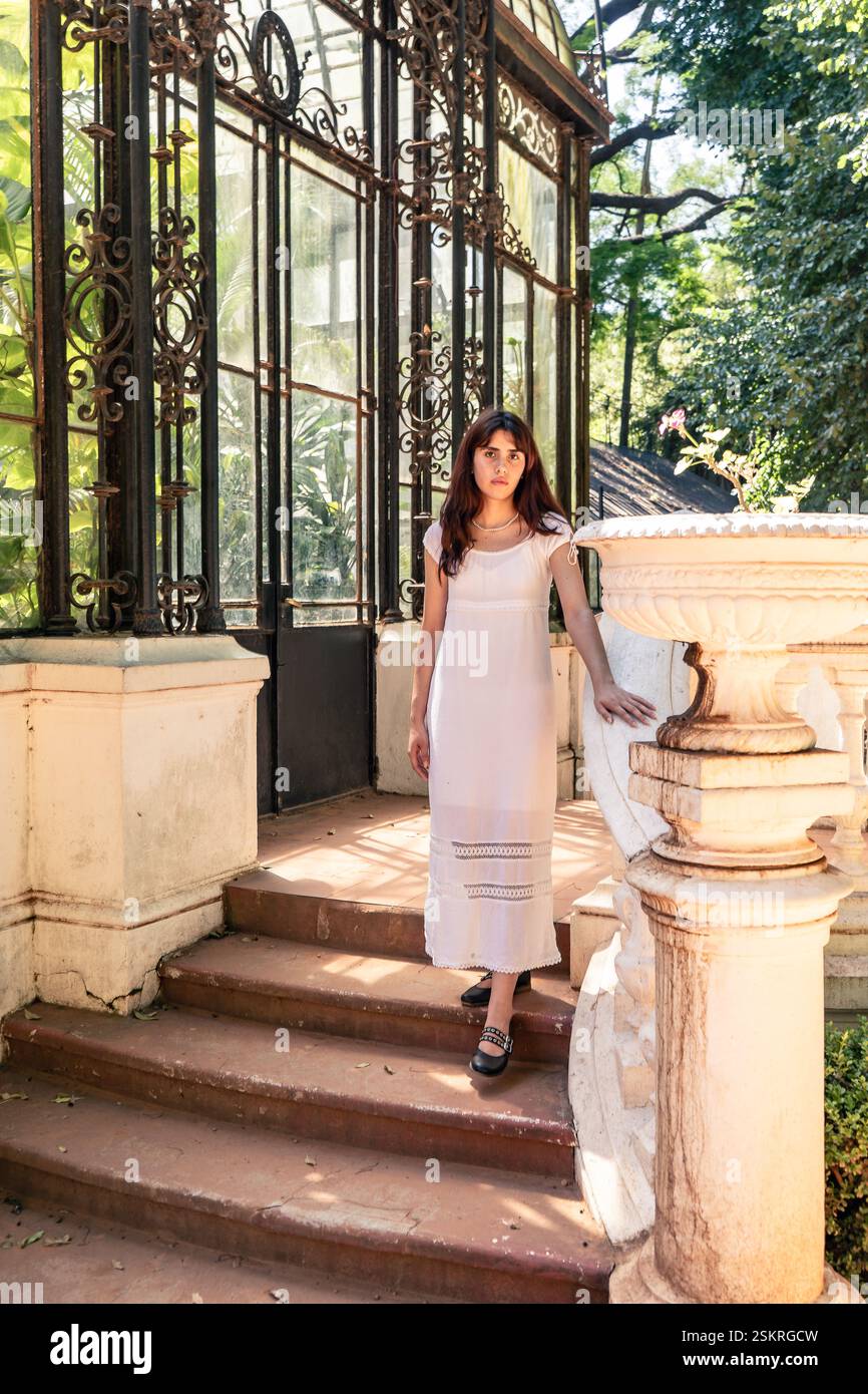 Fashion model posing in a botanical garden in front of a beautiful ...