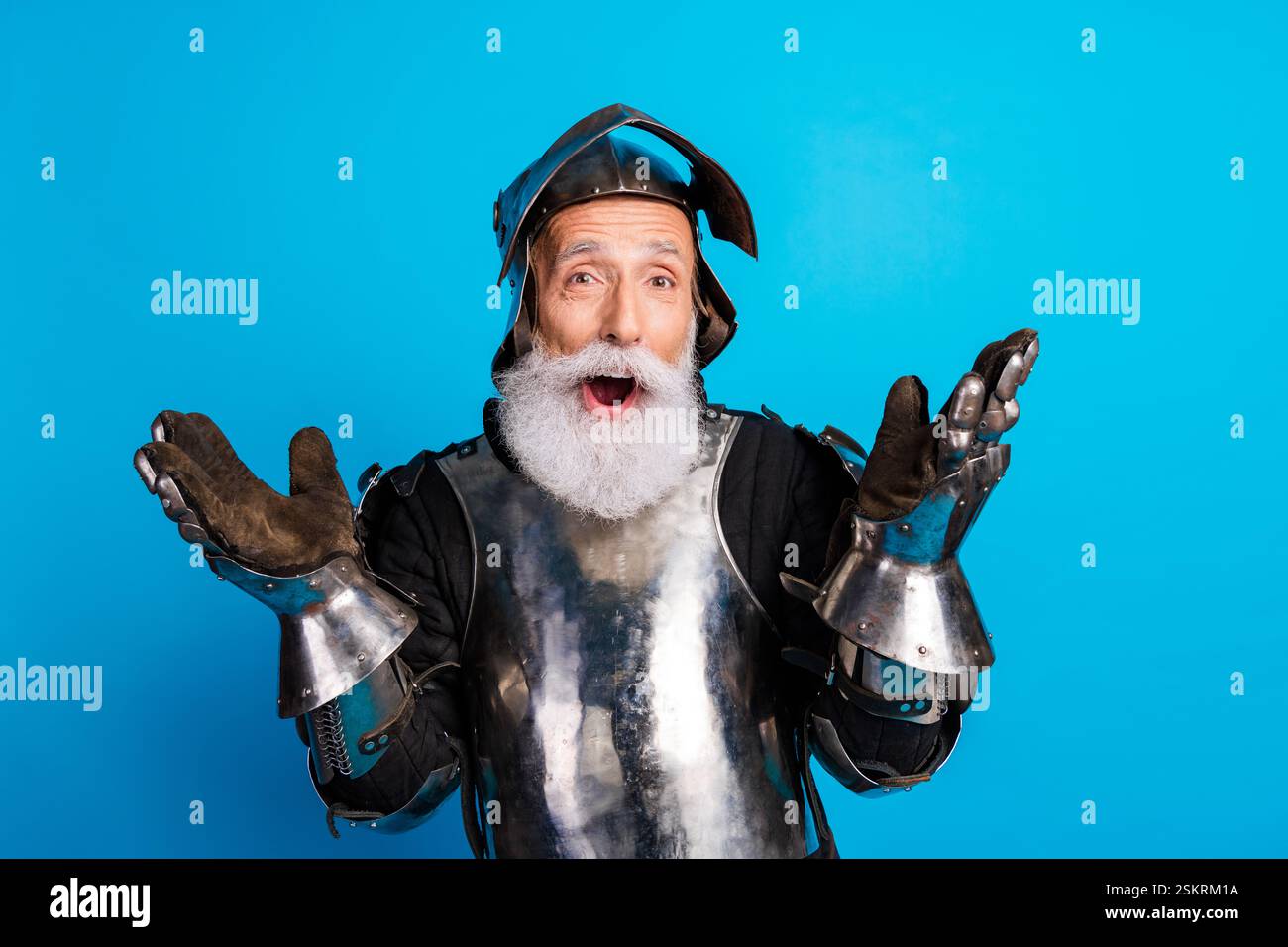 Elderly knight in shining medieval armor expressing surprise against a ...