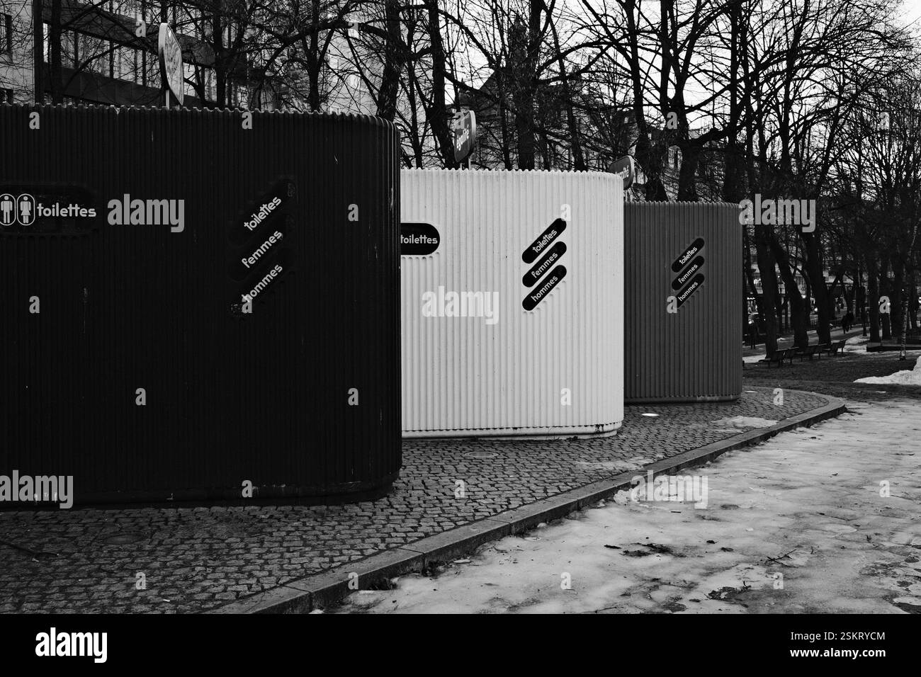 Three small buildings with black and white signs on them. The signs are ...