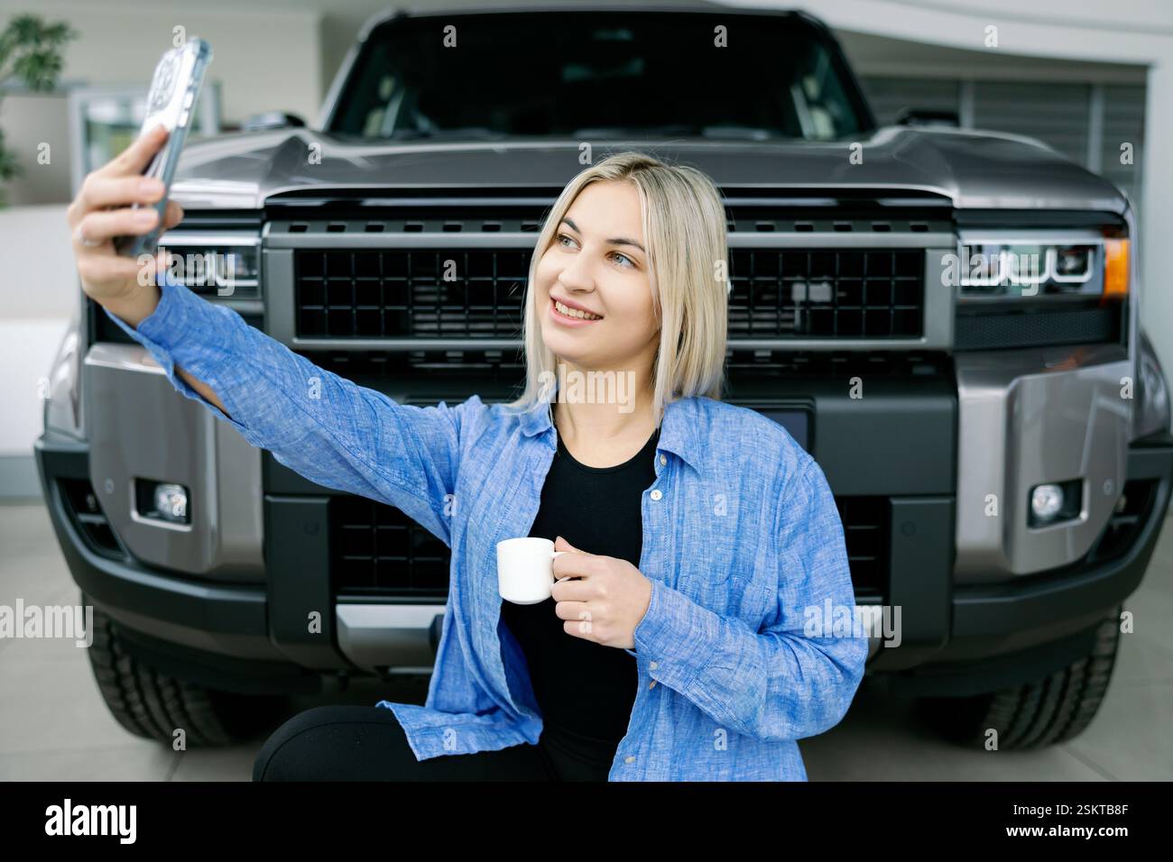 Happy customer enjoying a cup of coffee while taking a selfie with her ...