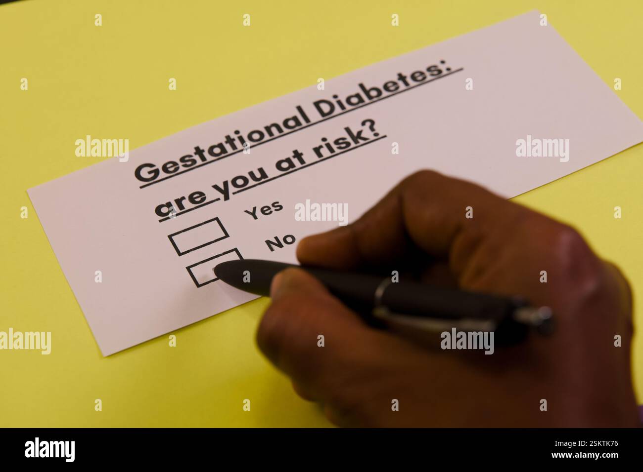 A hand marks a response on a risk assessment checklist for gestational ...