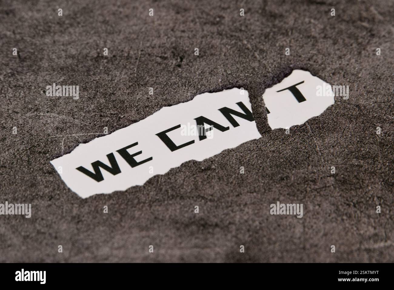 Torn paper letters form a motivational message on a textured surface ...