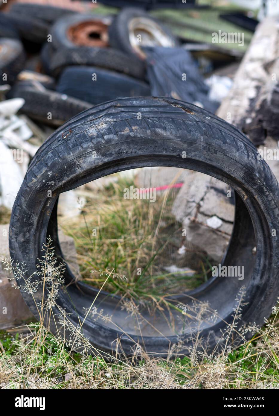 old tire at a recycling center with other scrap vertical Stock Photo ...