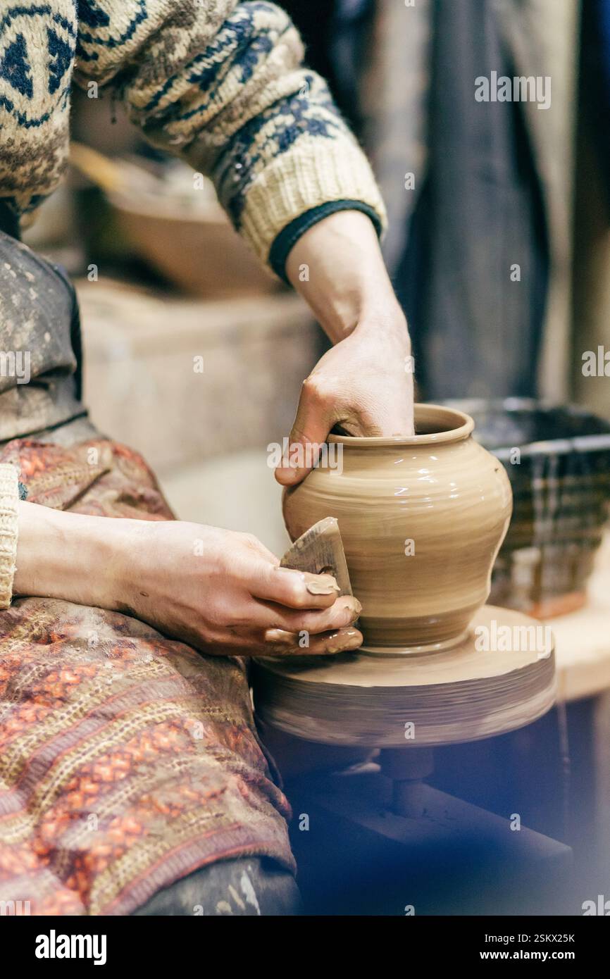 A potter makes a pot on a potter's wheel, Master class on modeling of ...