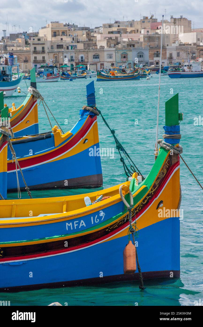 Prows of three brightly decorated traditional Maltese fishing boats ...