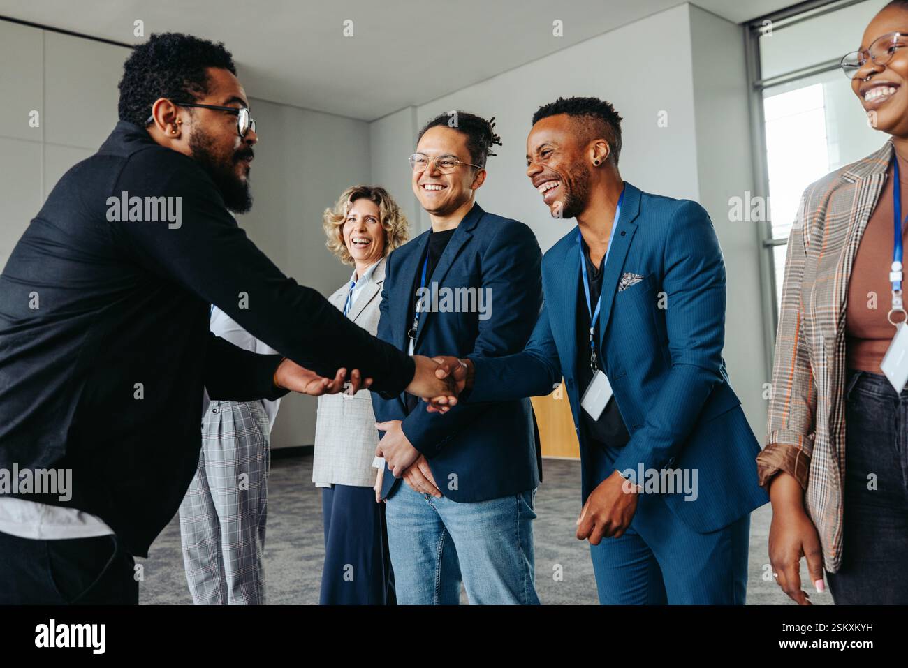 Diverse group of professionals greeting each other with handshakes at a ...