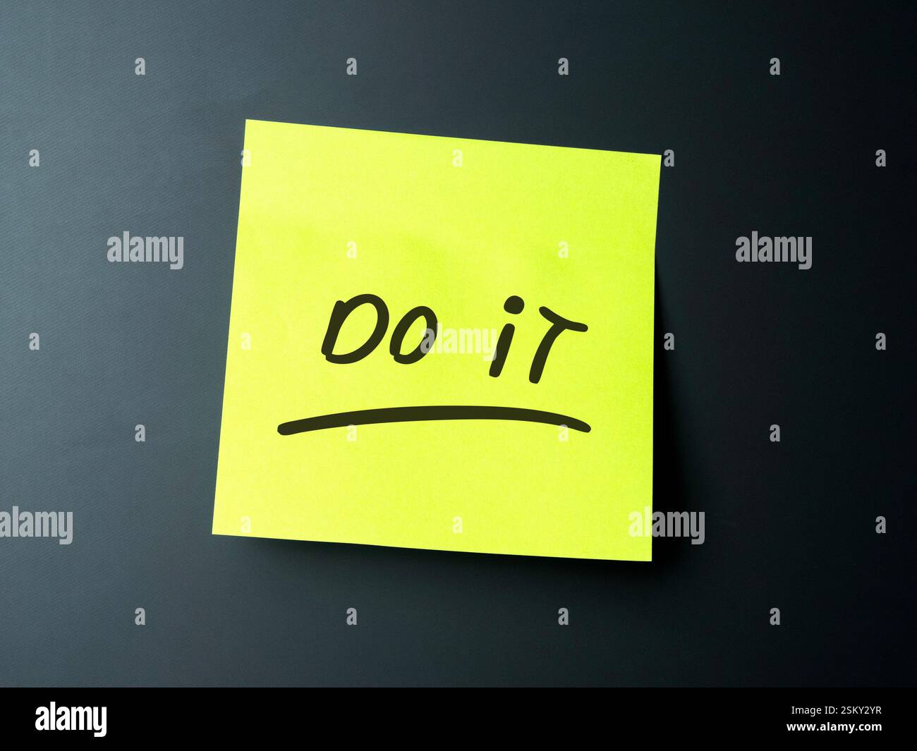 A bright yellow sticky note displays a motivating message to inspire ...