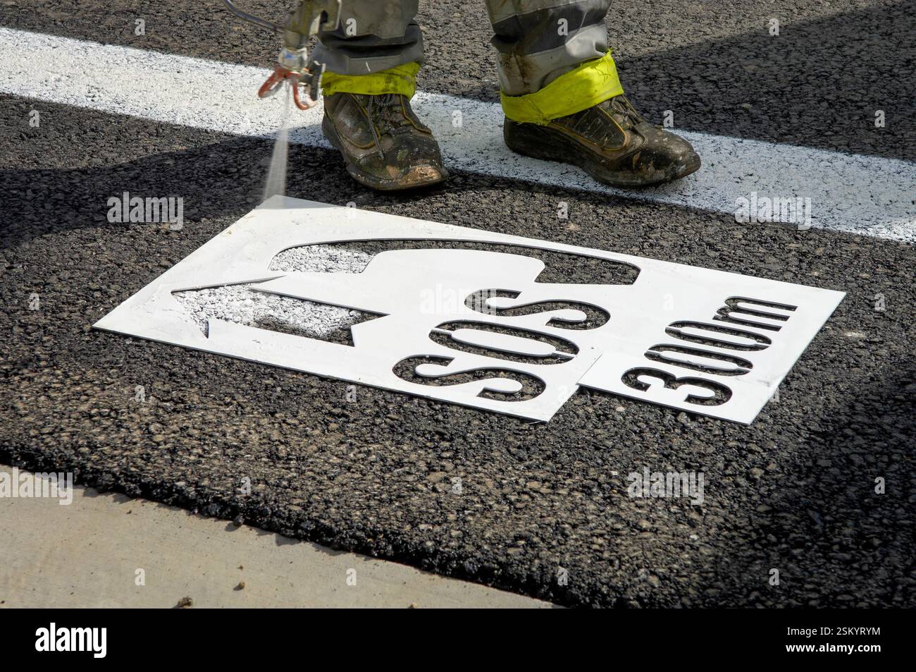 On a tarmac road, paint in white using a template, the distance to the ...