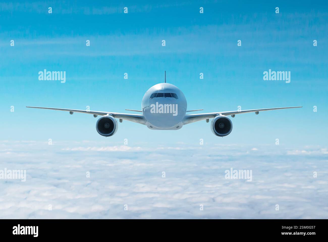 Front view of the white wide body passenger aircraft flying in the air ...