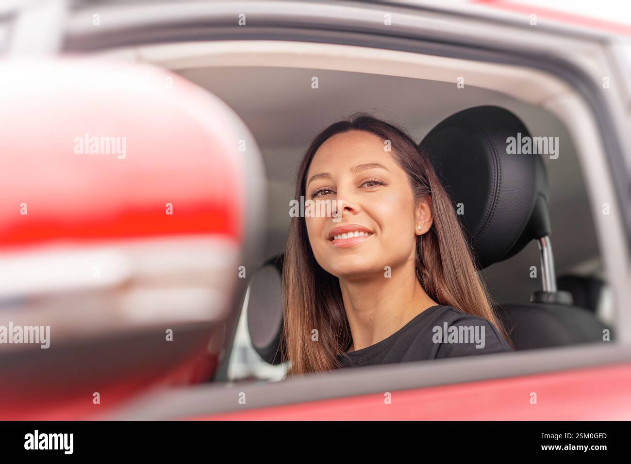 A young woman with long brown hair and a friendly smile sits in the ...