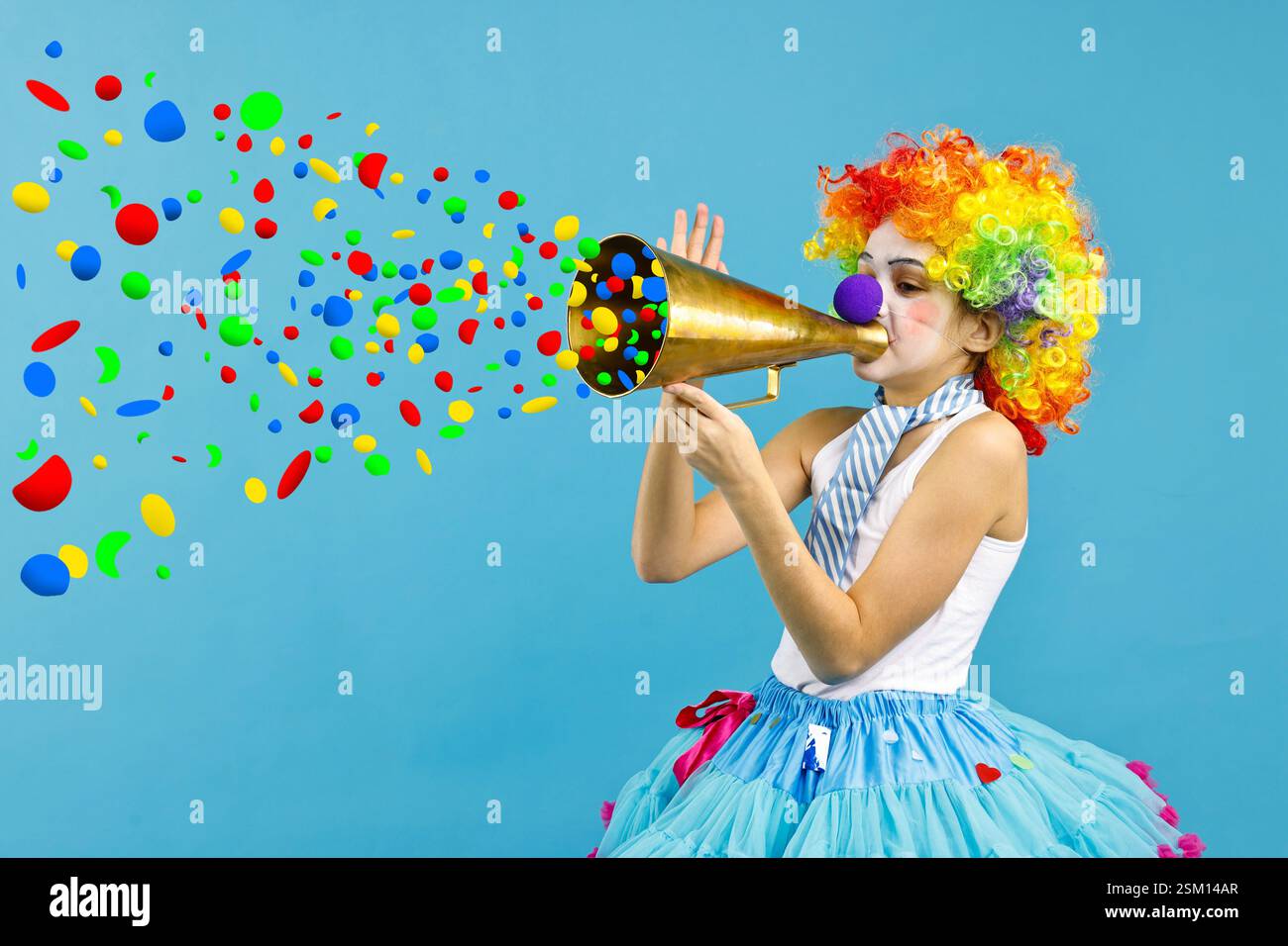 Cute girl dressed like clown shouting in megaphone with confetti flying ...