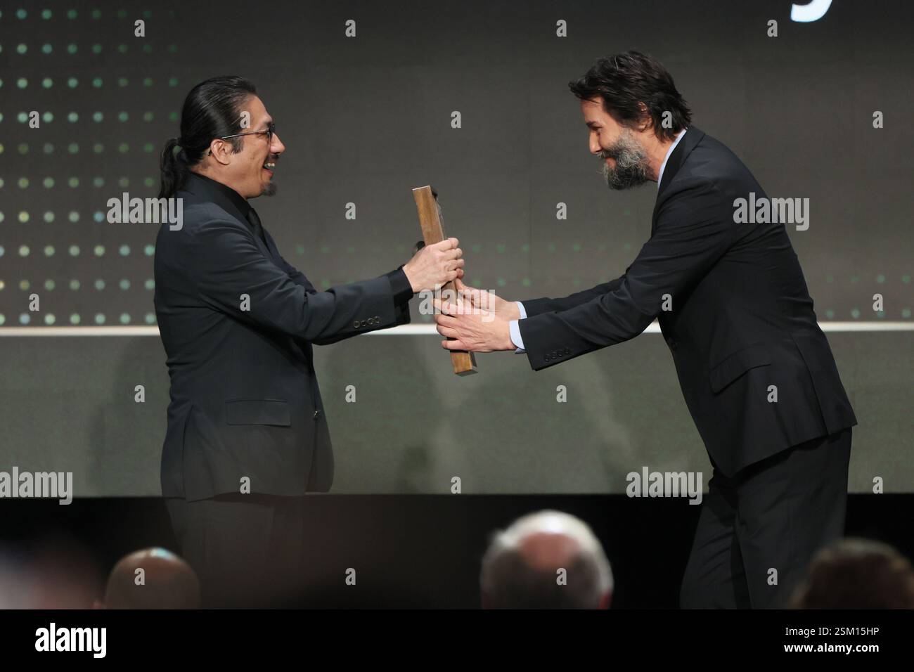 Beverly Hills, USA. 11th Feb, 2025. Keanu Reeves, right, presents the ...