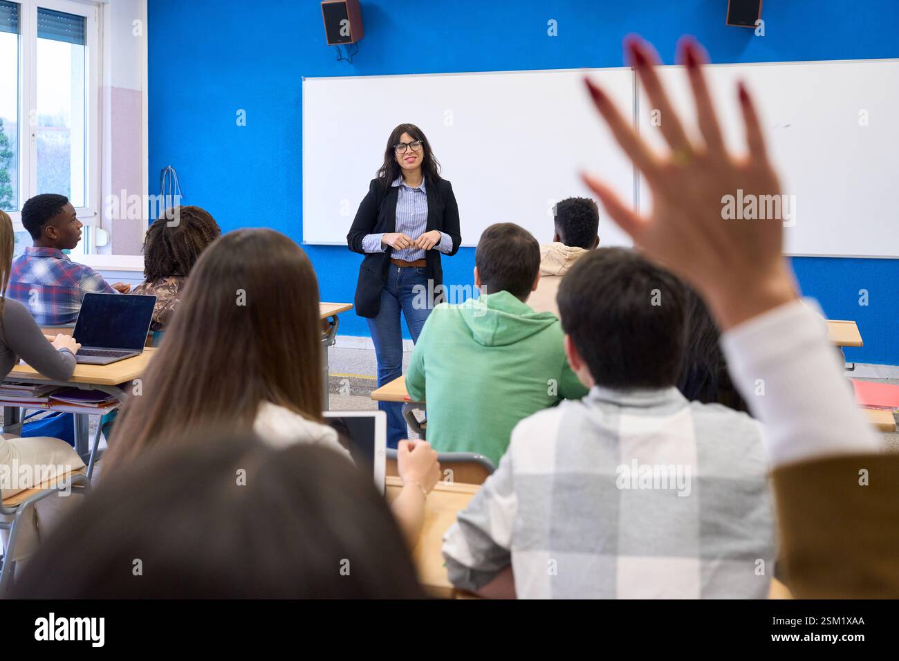 University students raising hand during lesson at institute Stock Photo ...
