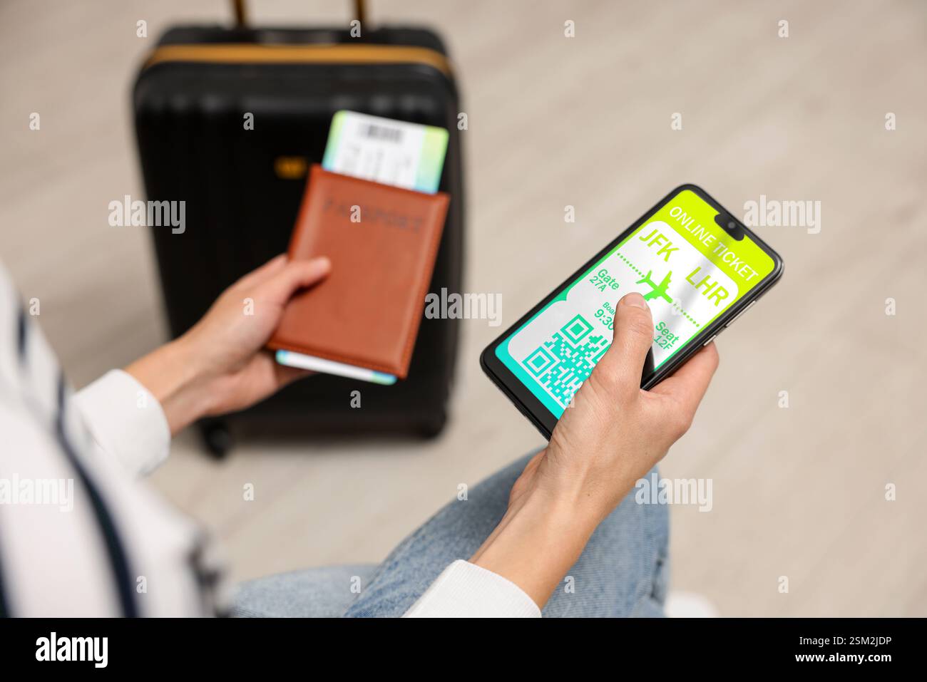 Tourist with passport, flight ticket and mobile phone indoors, above ...