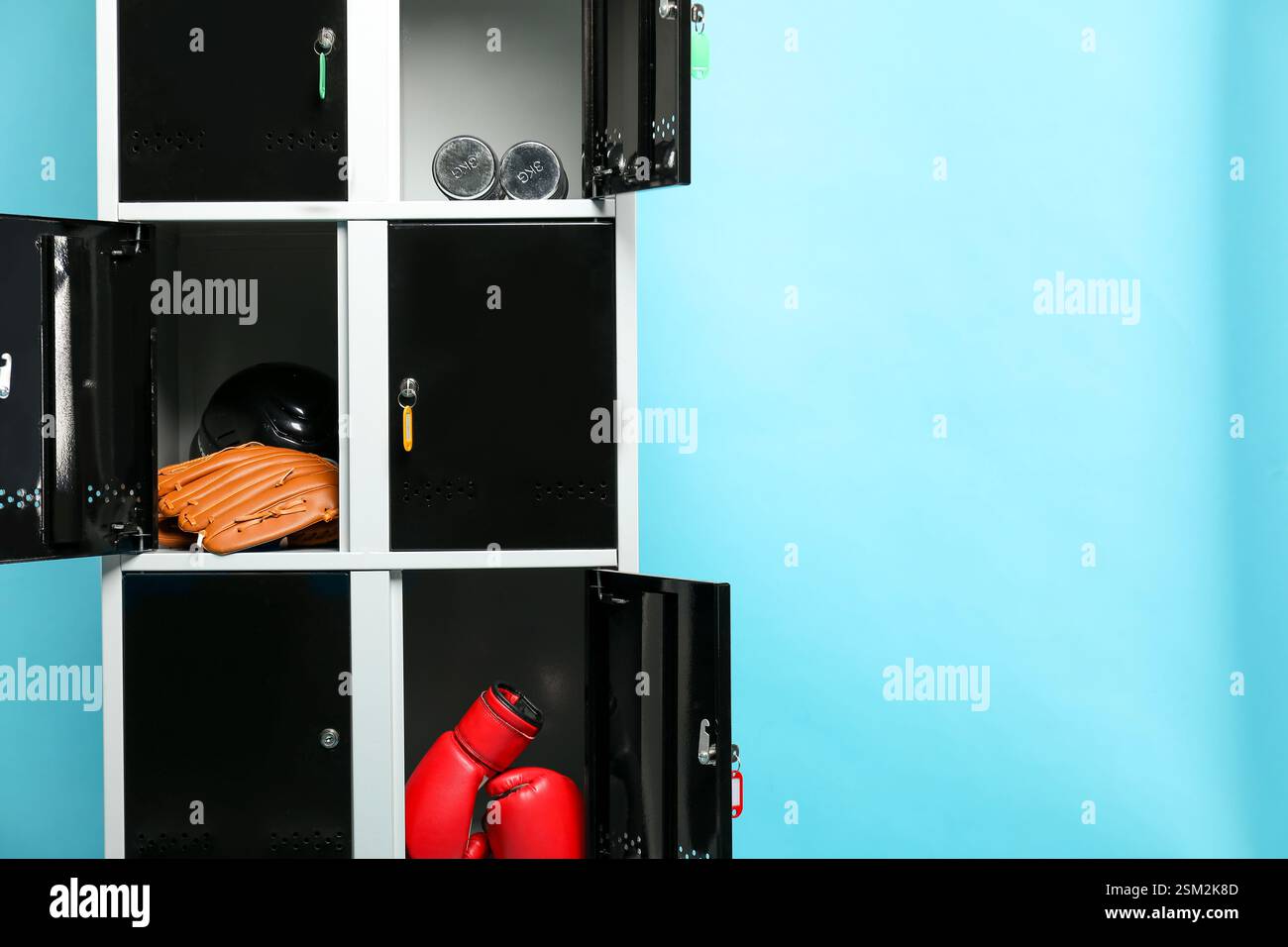 Open lockers with sport equipment on light blue background, space for ...