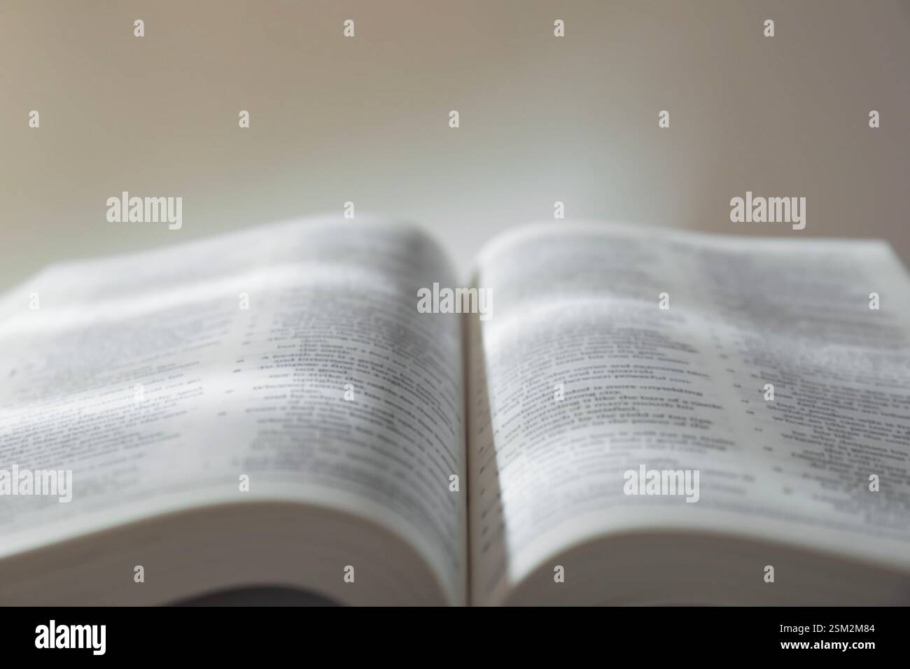 Open Holy Bible in English language against beige background, closeup ...