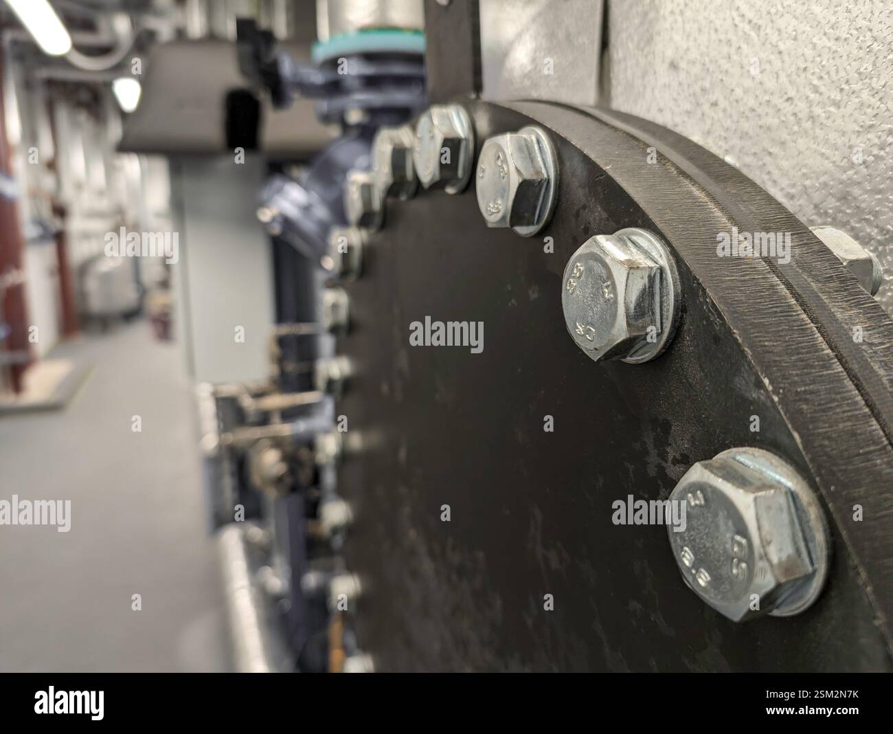 A large industrial pipe flange with multiple hexagonal bolts securing ...