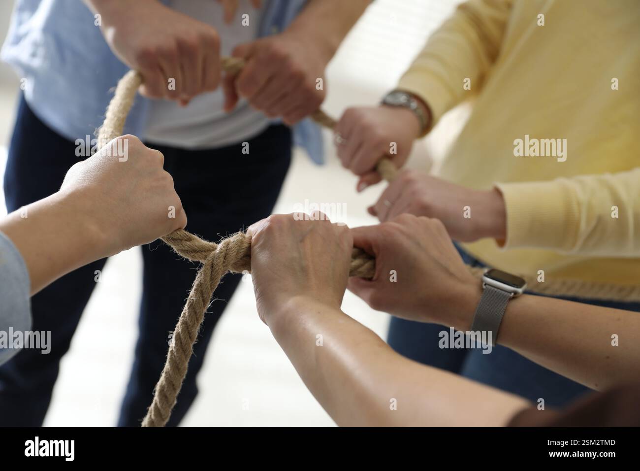 Unity concept. People holding rope together indoors, closeup Stock ...