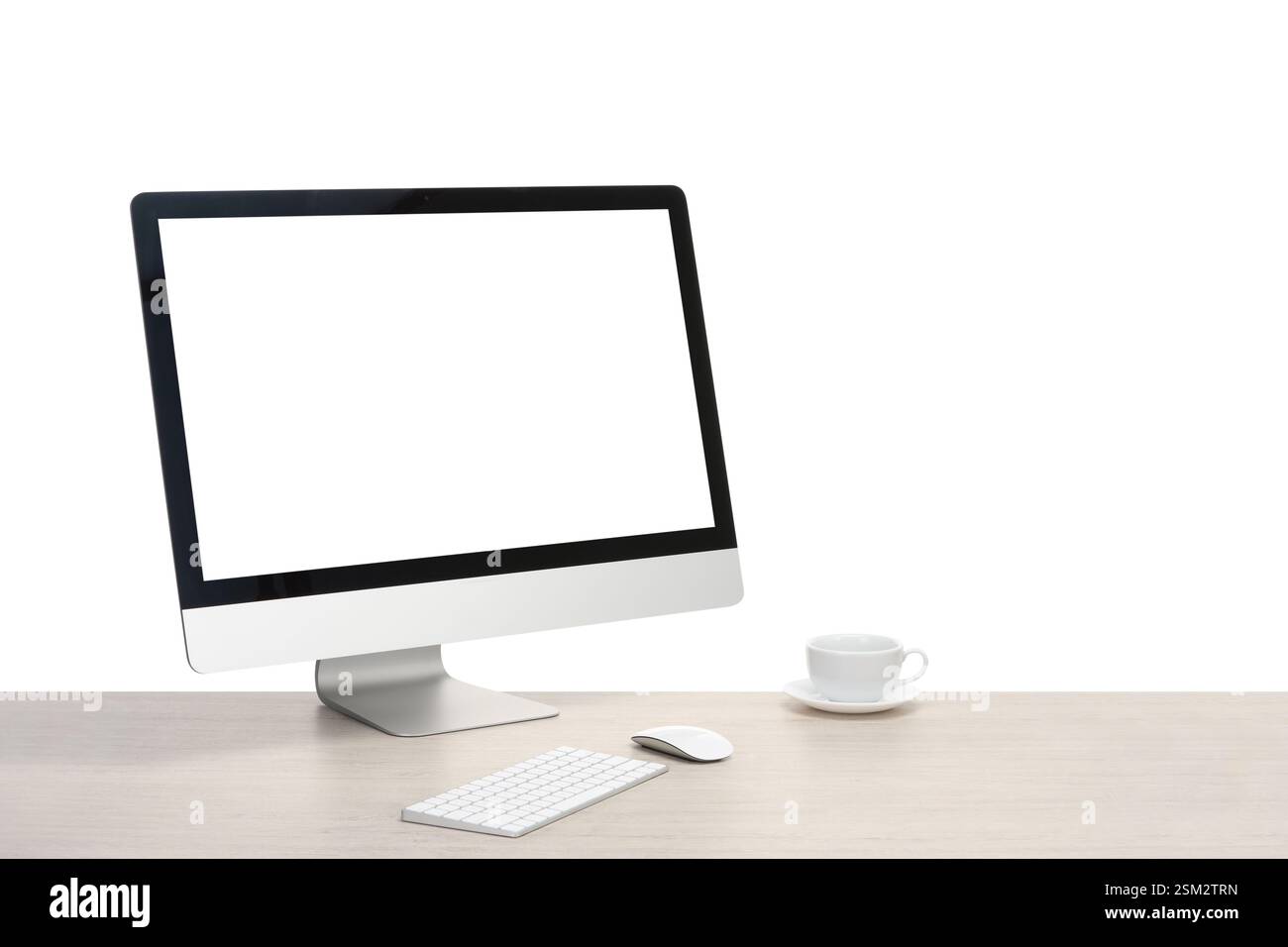 Computer monitor, keyboard, mouse and cup of drink on wooden desk ...