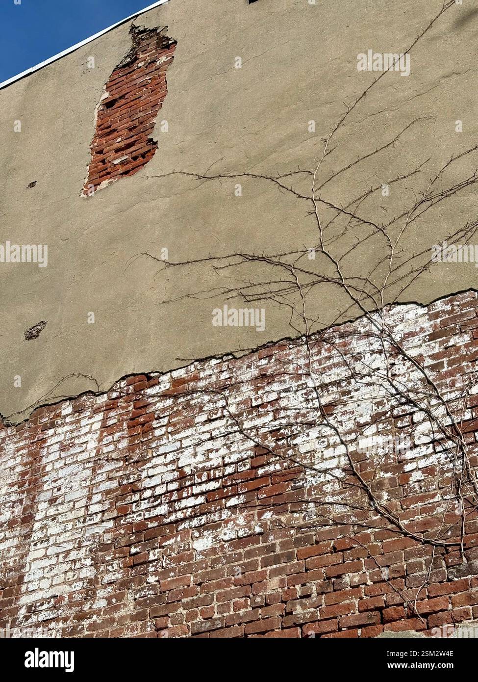 Side of a building with flaking stucco to reveal red brick Stock Photo ...