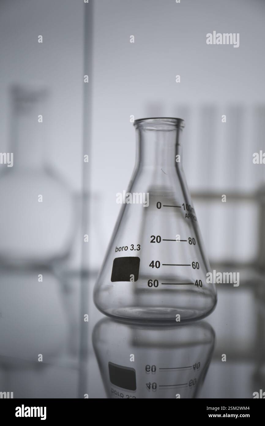 Empty flask on mirror surface against light background. Laboratory equipment Stock Photo - Alamy