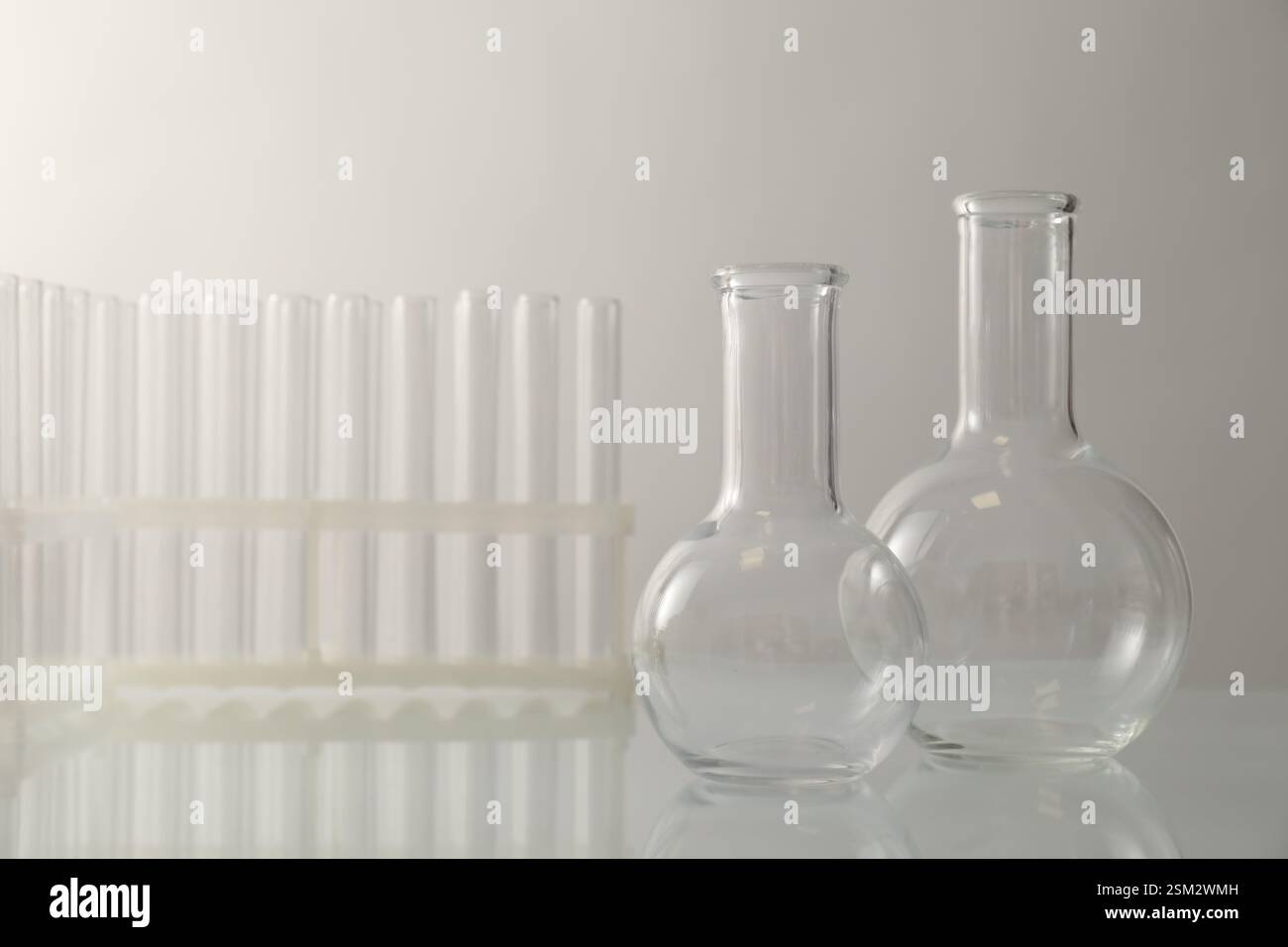 Empty flasks and test tubes on light background. Laboratory equipment ...