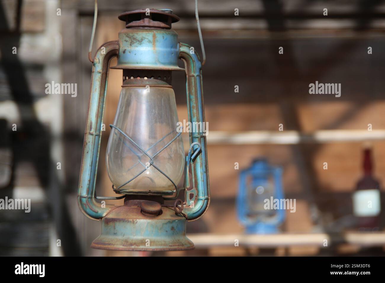Old fashioned blue kerosene lanterns hang outside of a wooden cabin to ...