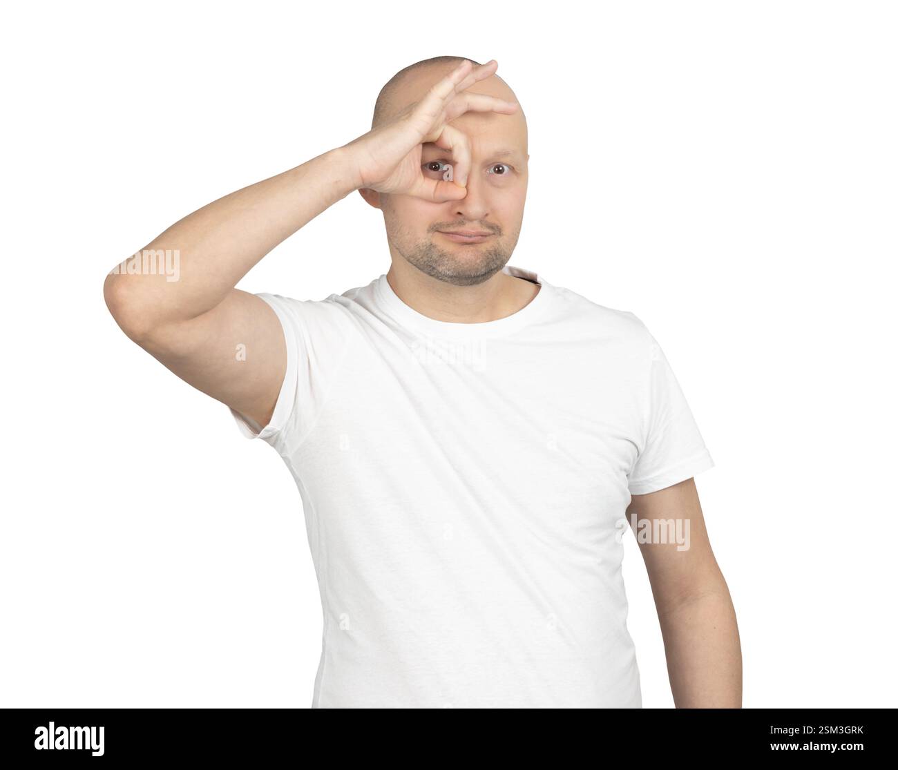 A bald man in a white t-shirt stands against a plain white background, forming an "OK" sign with ...