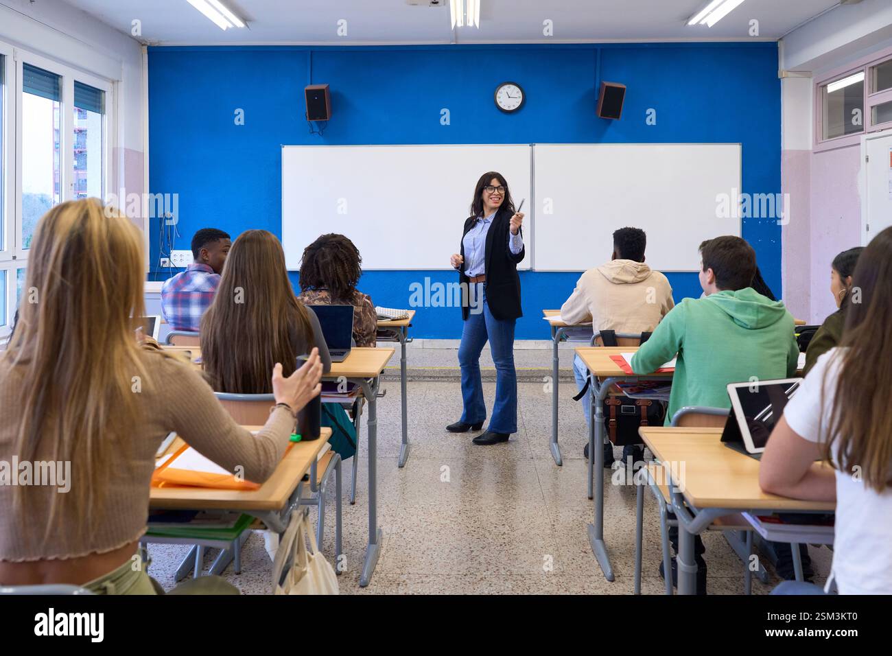 Teacher explaining lesson to diverse high school students institute ...