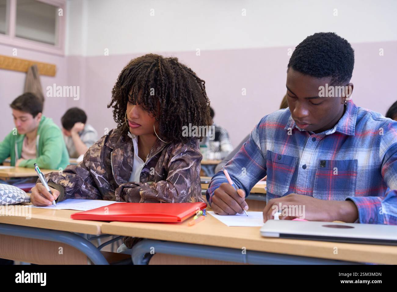 University students taking exam, writing notes in classroom Stock Photo ...