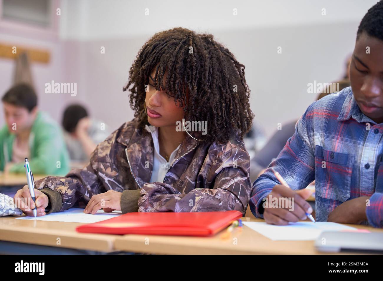 Focused students writing exam in university classroom Stock Photo - Alamy