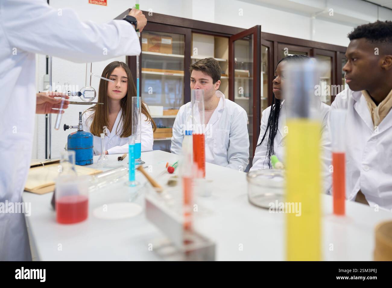 Chemistry teacher performing experiment for students in laboratory ...