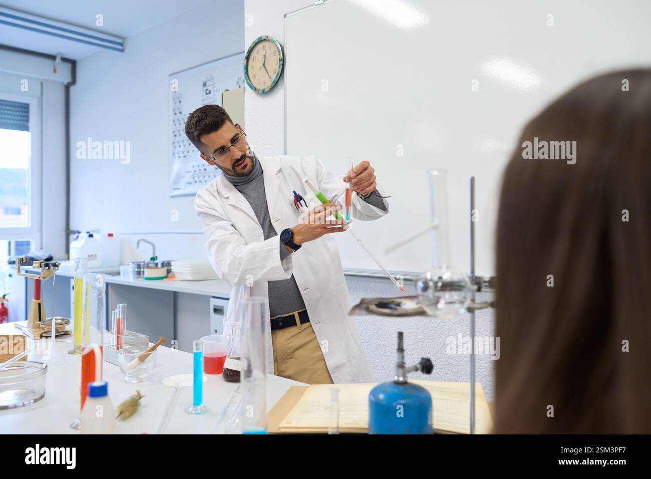 Chemistry teacher performing experiment for students in laboratory ...