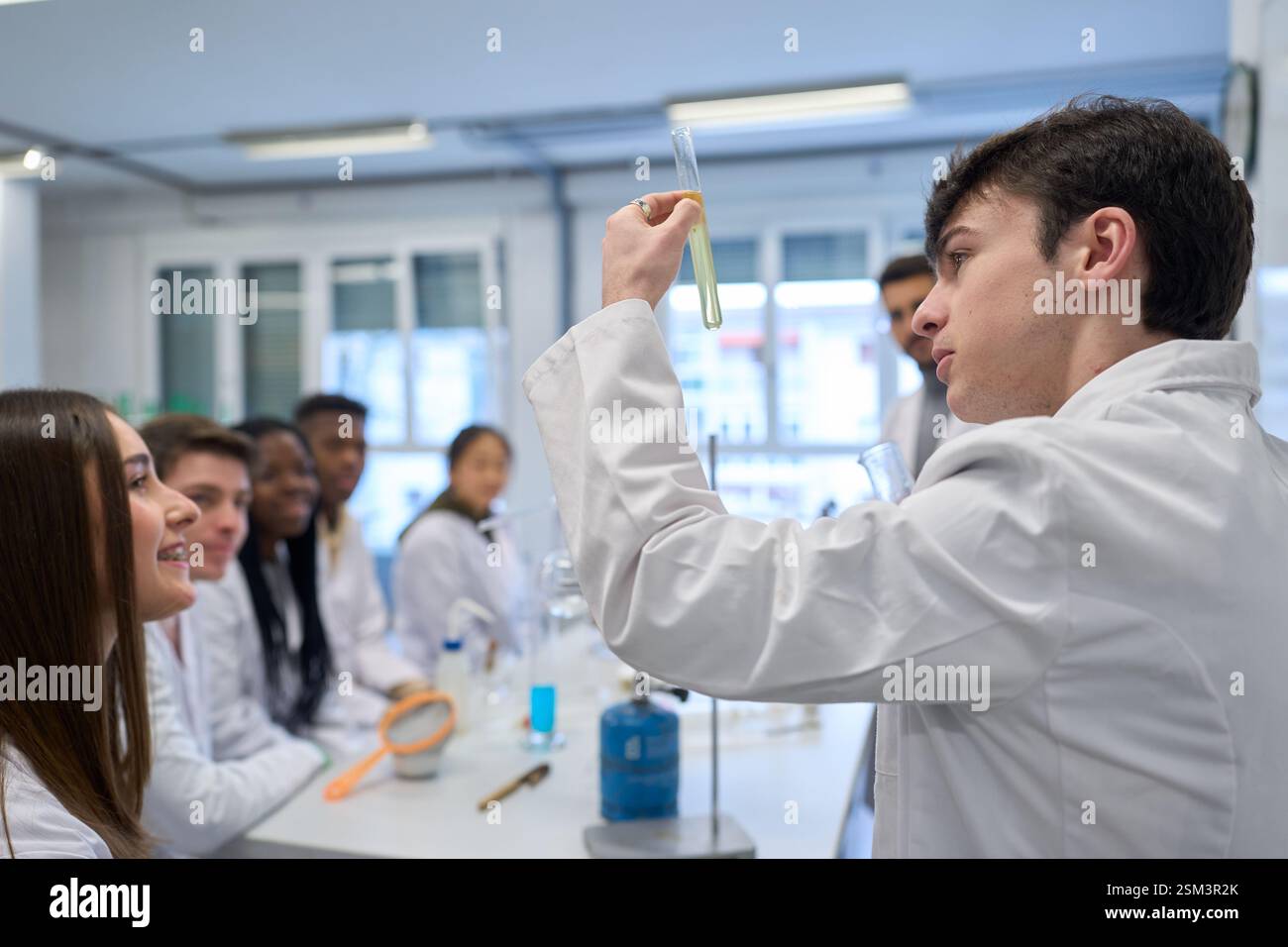 Chemistry student holding test tube observing chemical reaction in ...