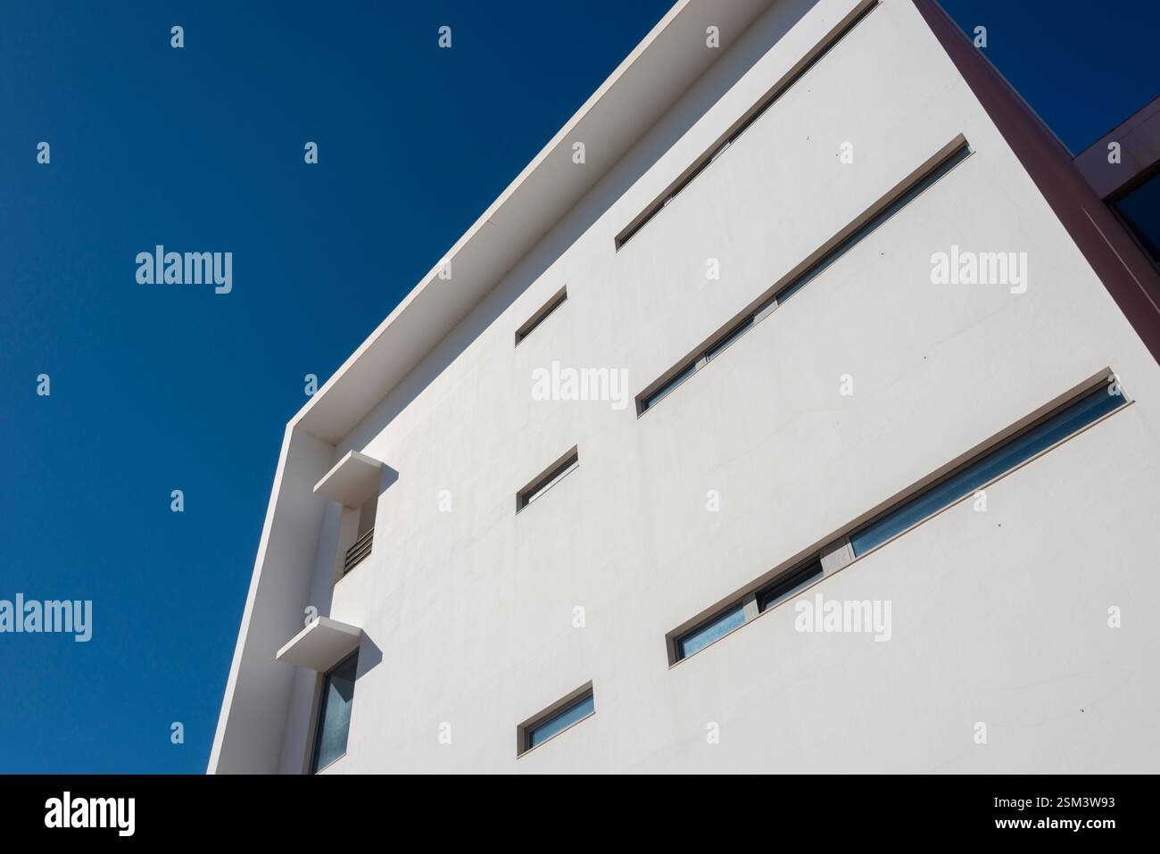 side of a modern concrete building against a blue sky background Stock ...