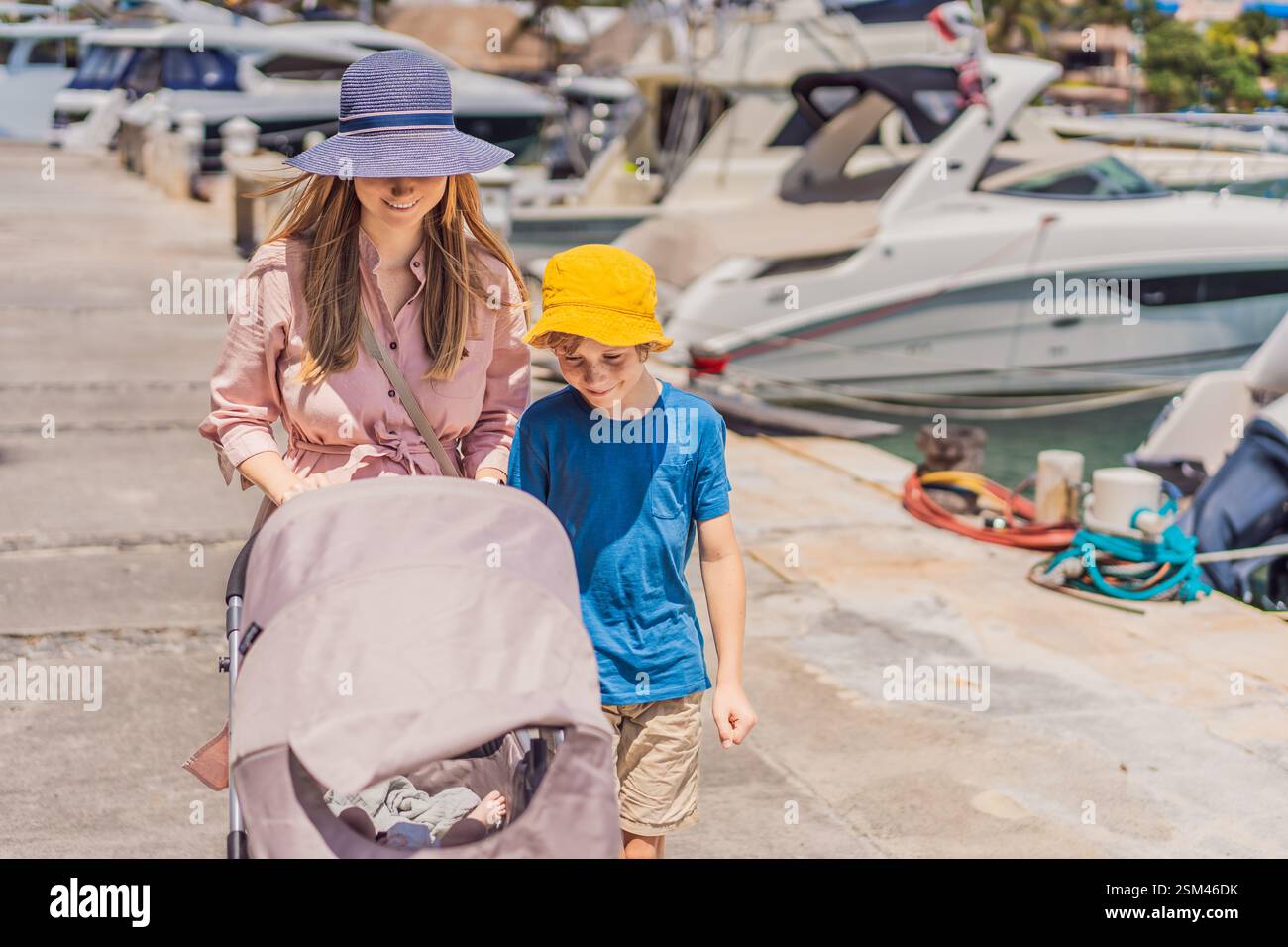 A mother and her elder son enjoy a peaceful walk along the waterfront ...