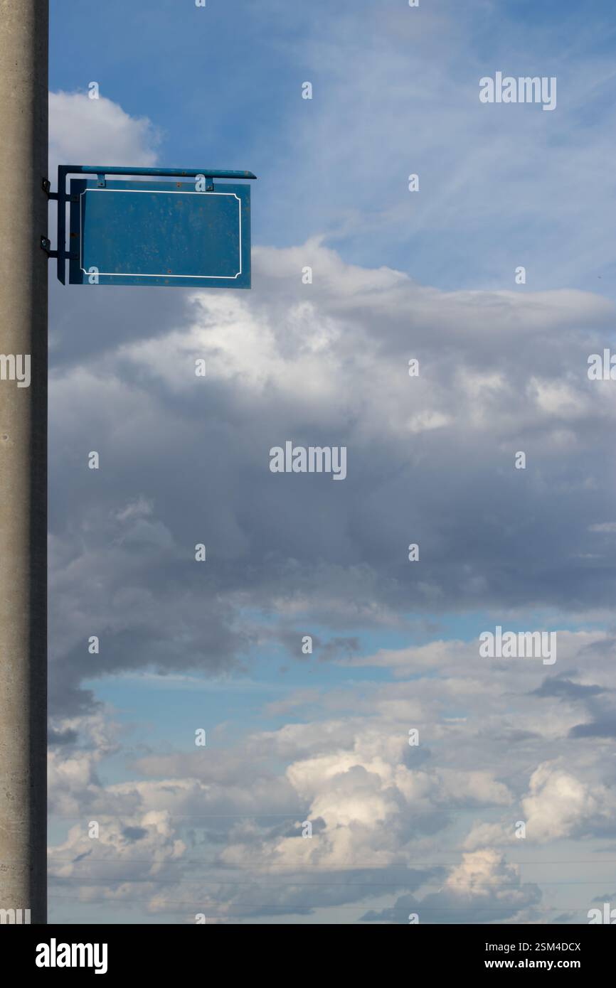 Blue rectangular metal sign with decorative border mounted on a pole ...