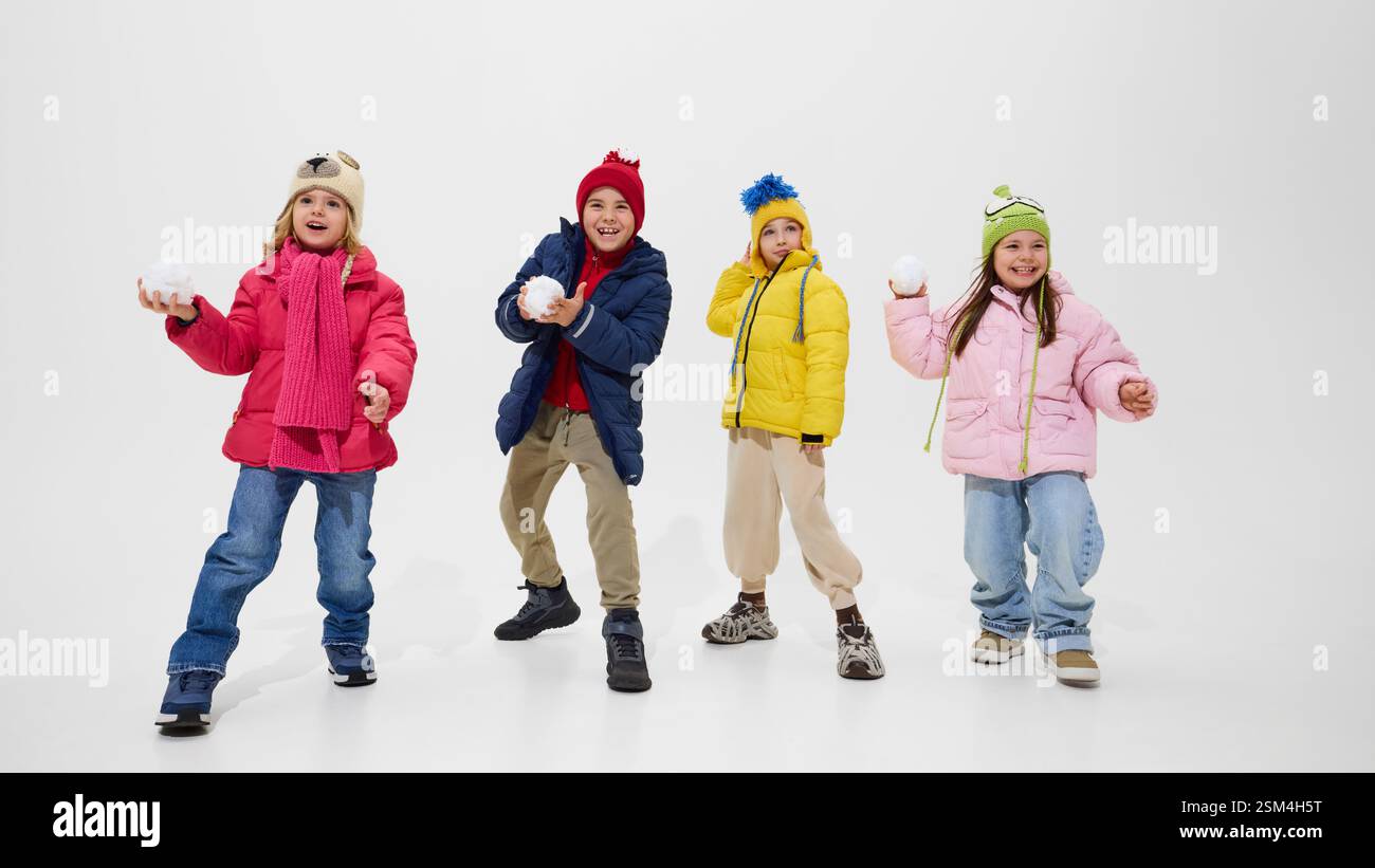 Group of children, dressed cozy winter clothes, standing in playful ...