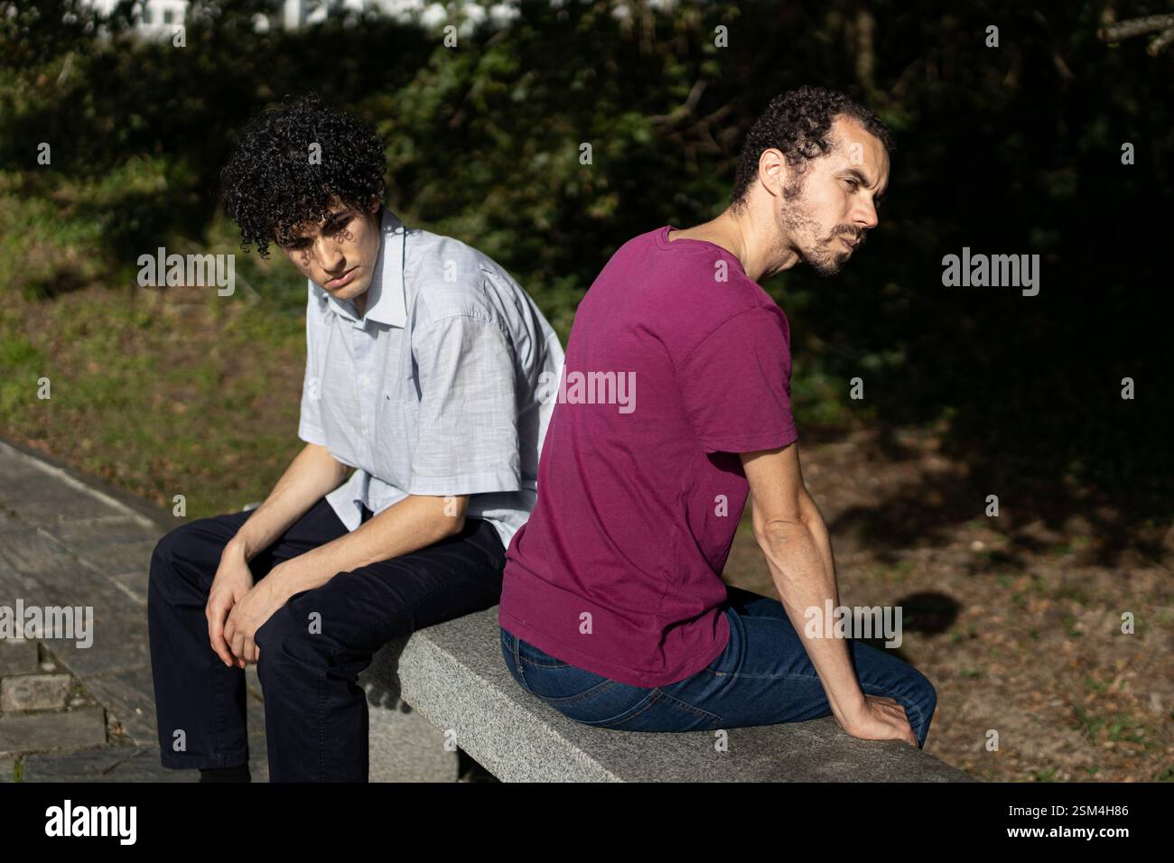 Two men having relationship problems and feeling angry while sitting on ...