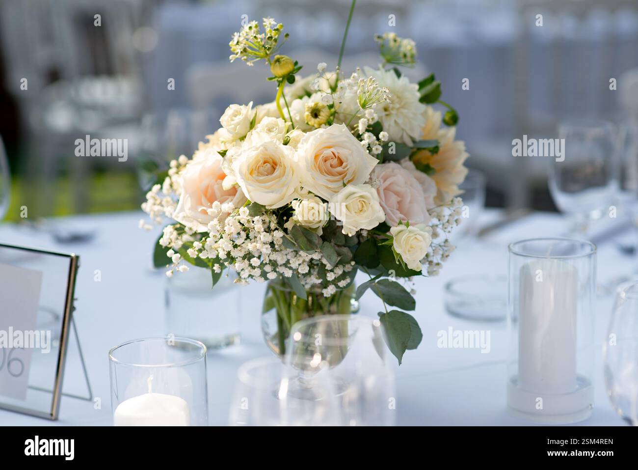 A stunning floral arrangement featuring delicate roses and greenery sits gracefully on a ...