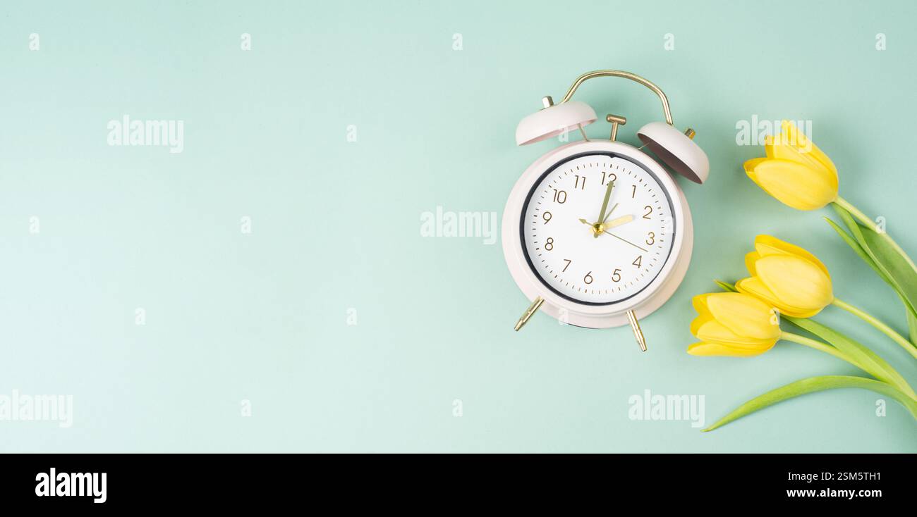 Alarm clock with yellow tulip flowers, switch to daylight saving time ...