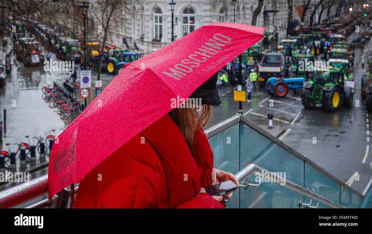 A tourist shields themselves from the rain under their elegant Moschino ...